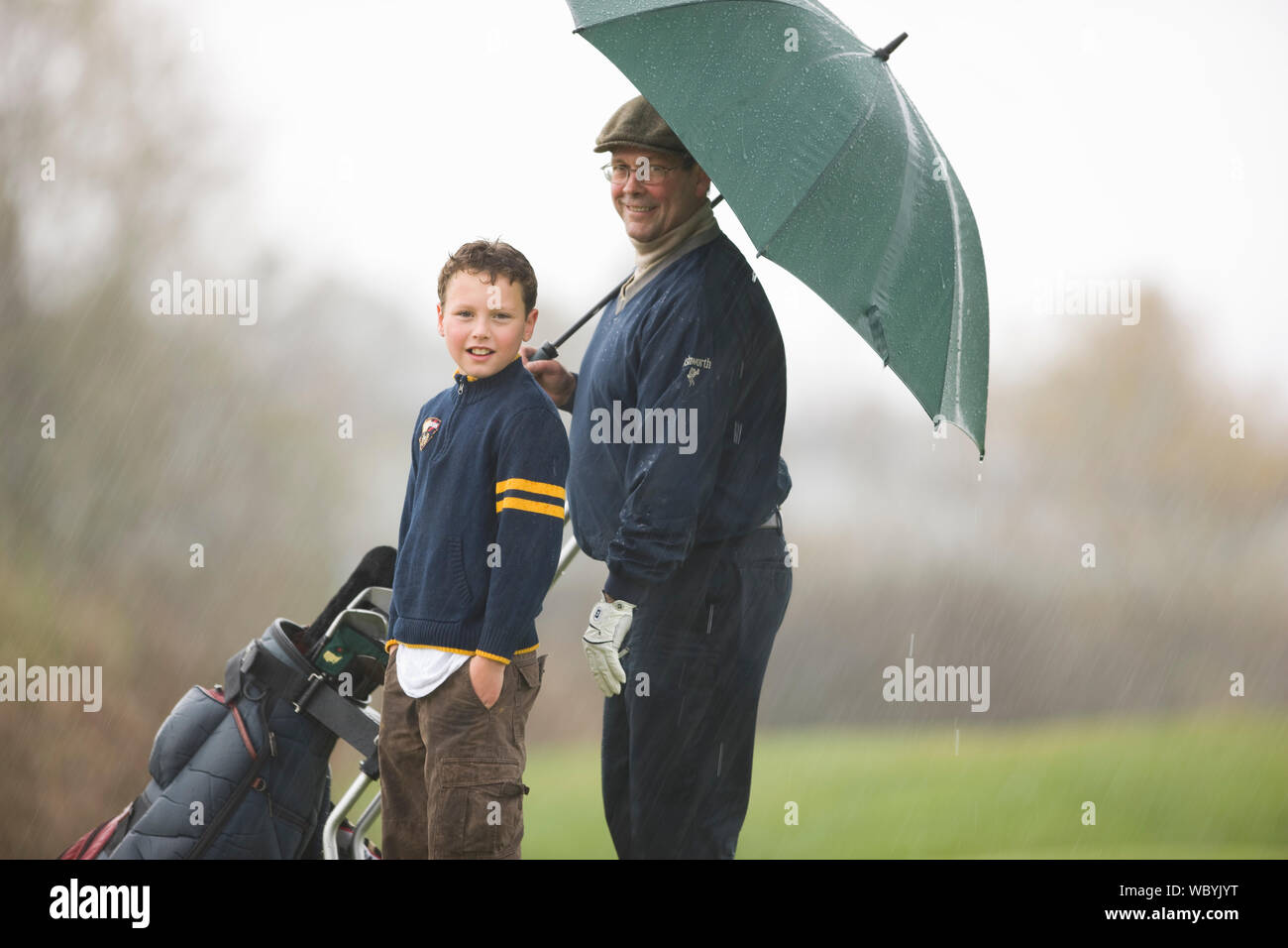 A boy and his father on a golf course Stock Photo - Alamy