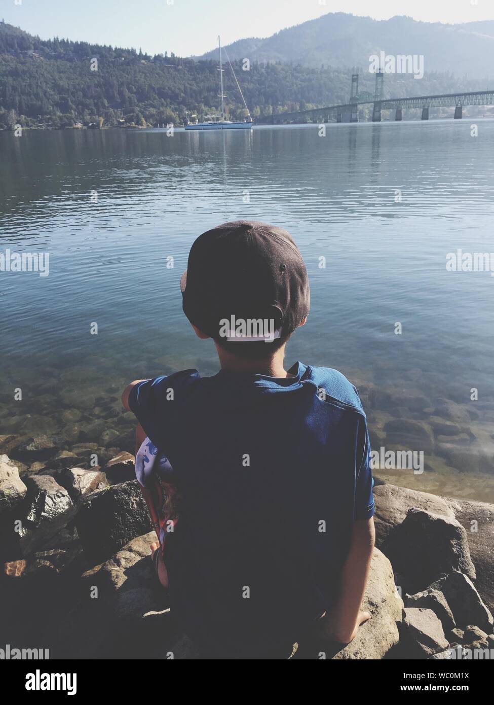 Boy sitting on rocks hi-res stock photography and images - Alamy