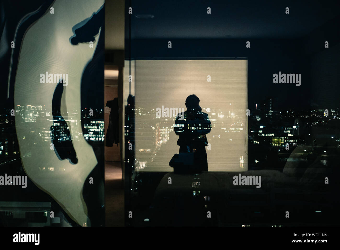 Man looking cityscape through window hi-res stock photography and ...