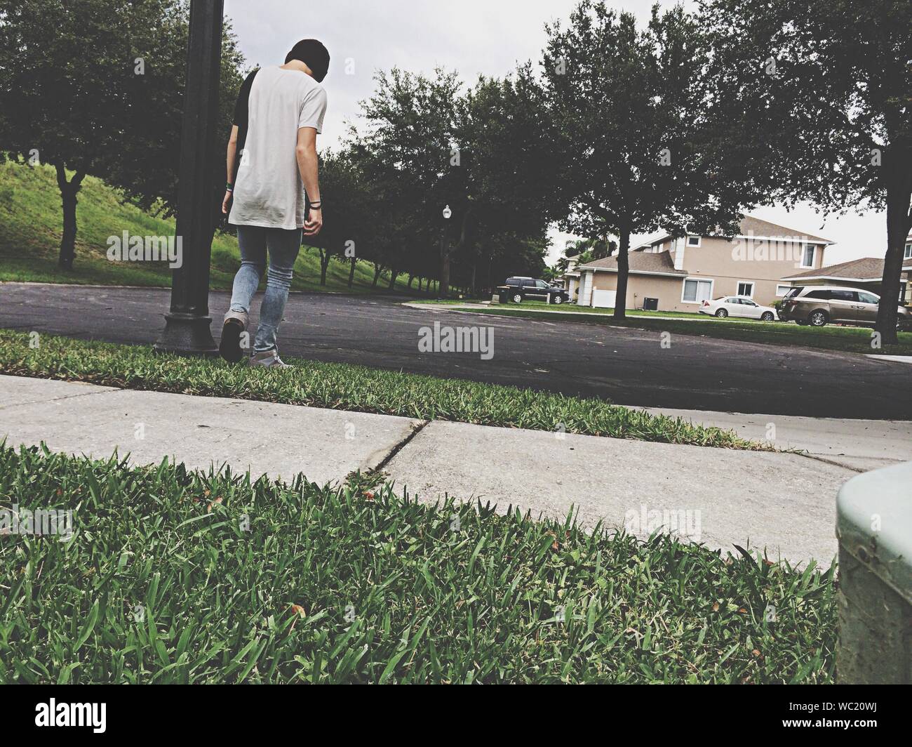 Rear View Of Man Walking Towards Road Stock Photo - Alamy