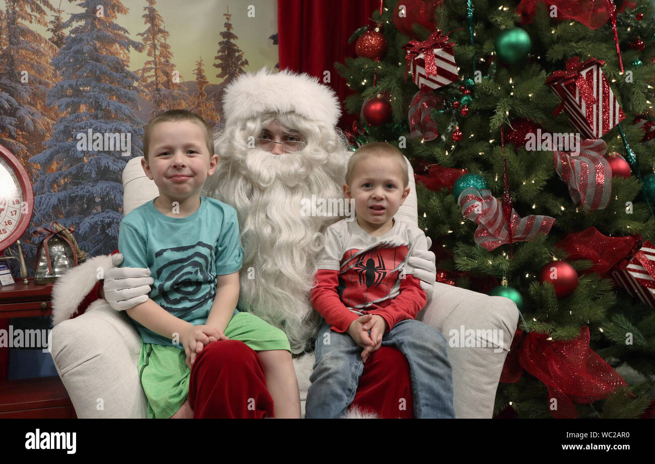 Boy sitting on Santa Clause's lap telling Santa what he wants Stock ...
