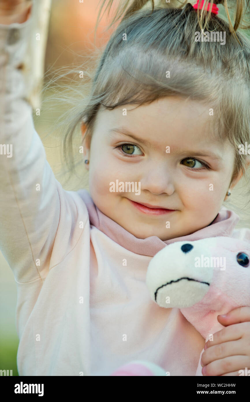 Kid girl with smile on adorable face play with toy Stock Photo - Alamy
