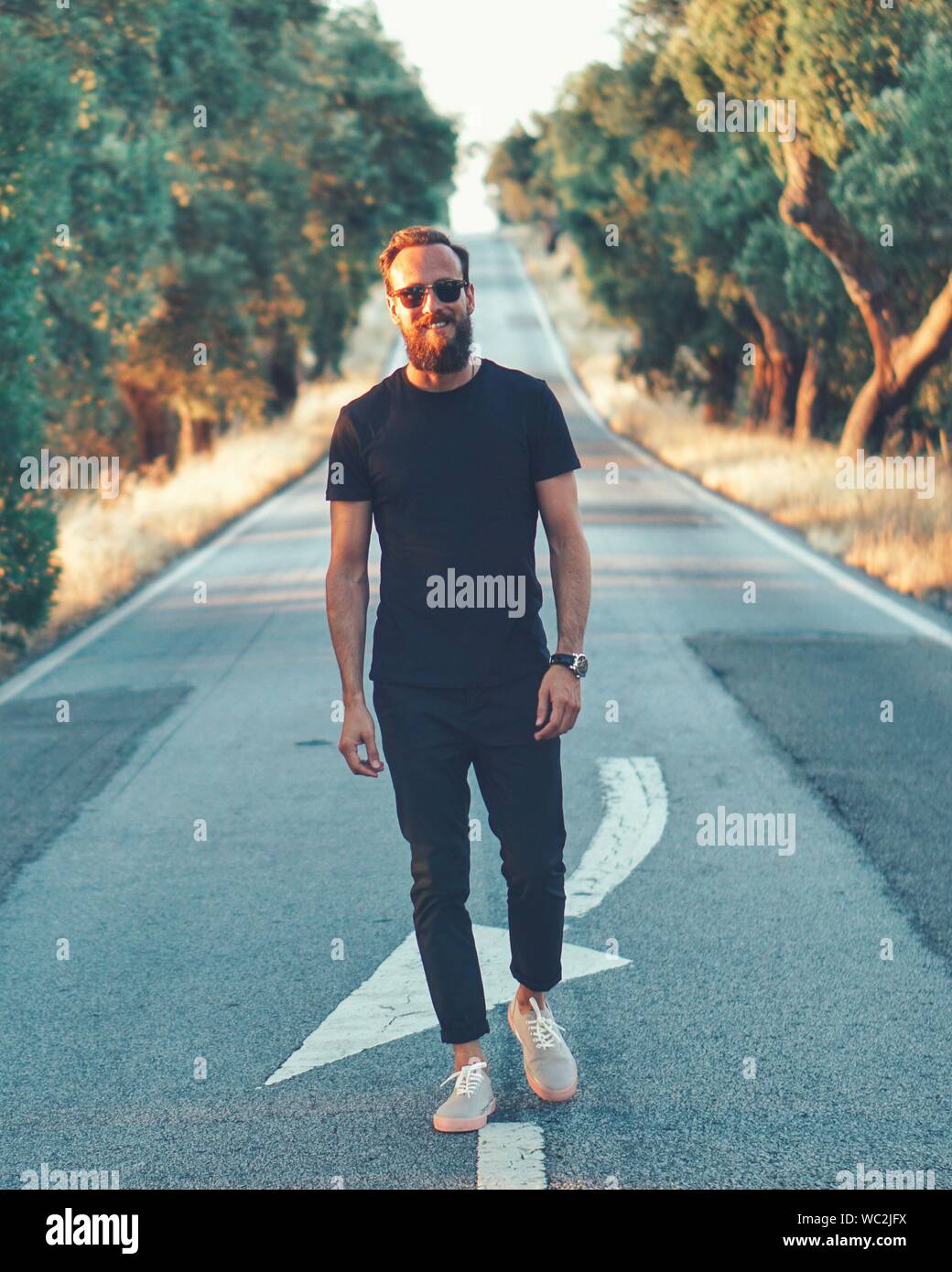 Young man walking on road hi-res stock photography and images - Alamy