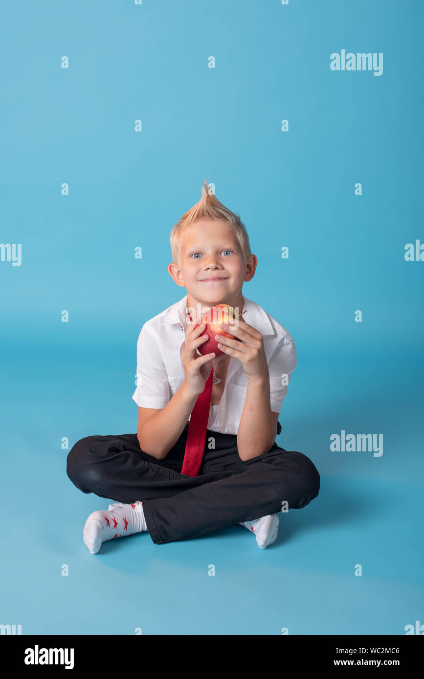 Close-up of a blond boy.The boy is posing on the camera. He is charming ...