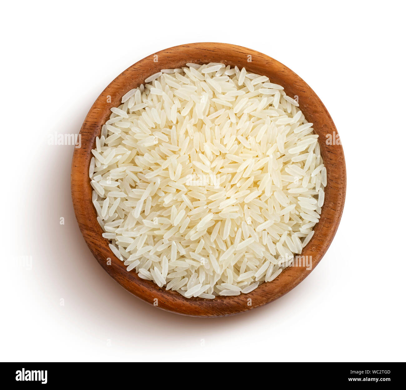 Basmati rice groats in a wooden bowl isolated on white background with ...