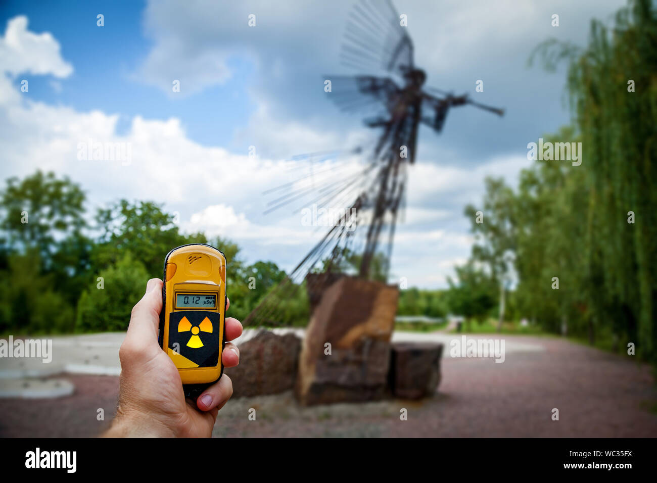 Dosimeter in hands with a level of radioactivity near the monument in ...
