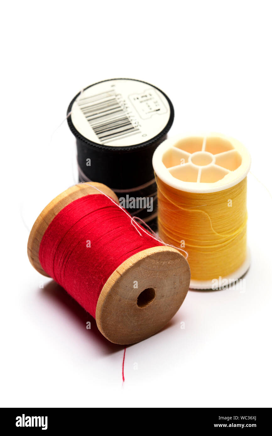 Group of spools of sewing thread in vaious stages of use and color ...