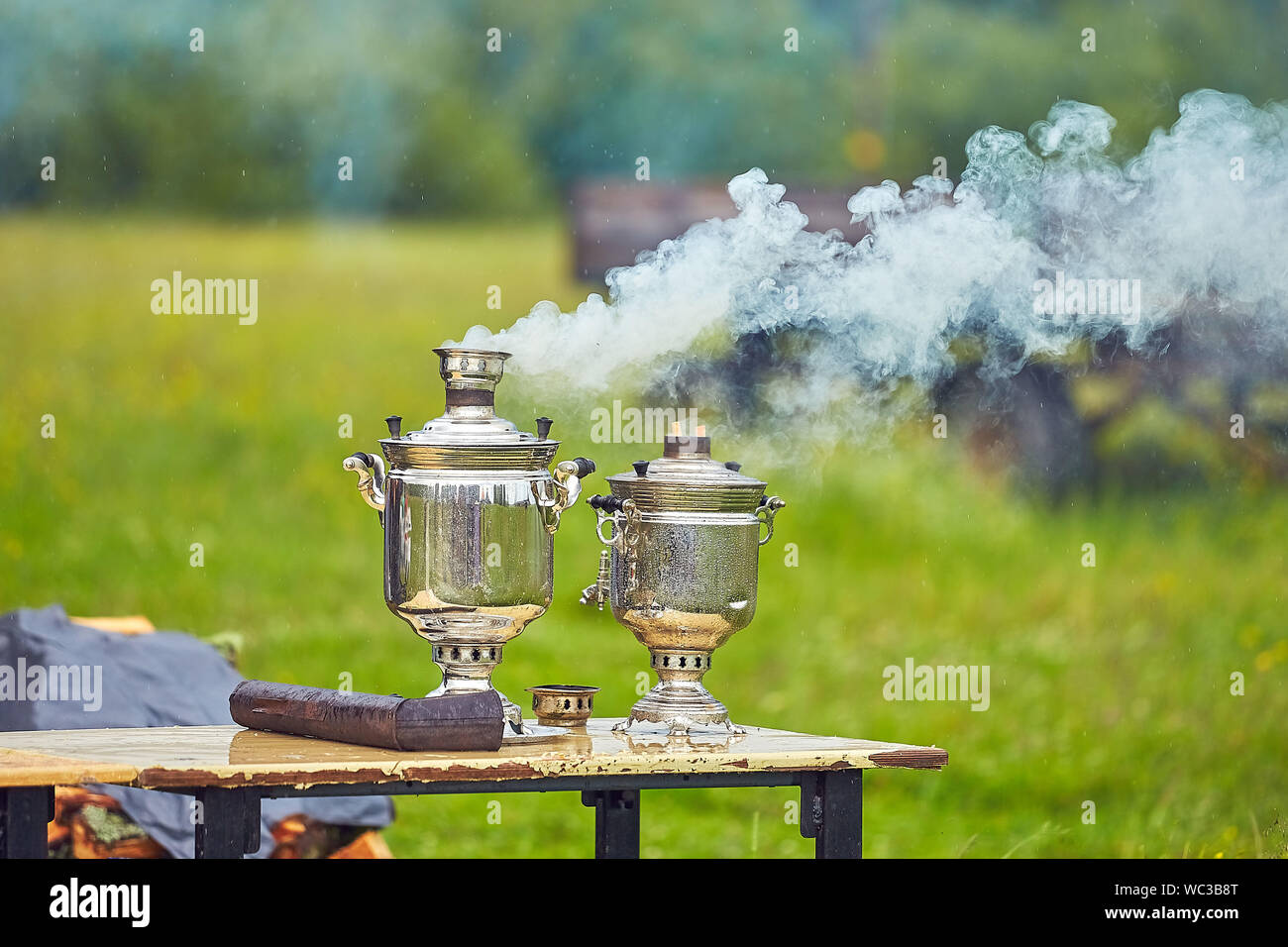 two samovars are on the table, the white smoke of a samovar in the ...