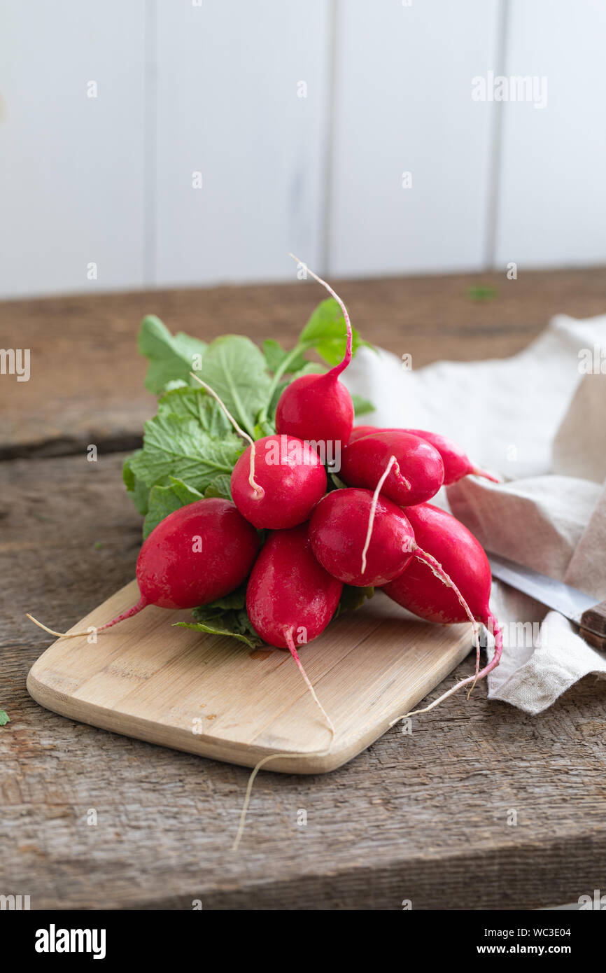 Fresh bunch of radish on wooden table, toned Stock Photo - Alamy