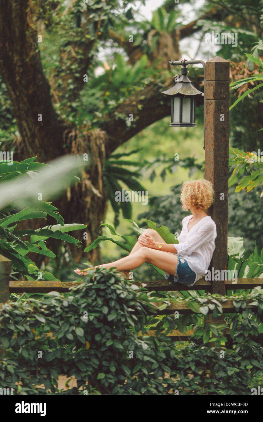 Woman sitting on fence hi-res stock photography and images - Alamy