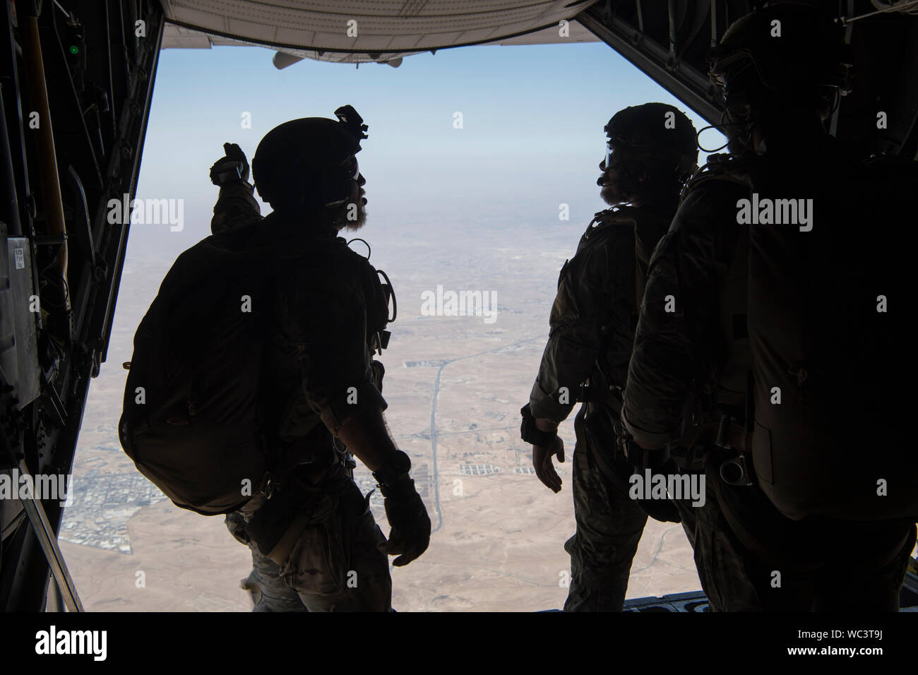 A U.S. Air Force Special Tactics jumpmaster signals a teammate to ...