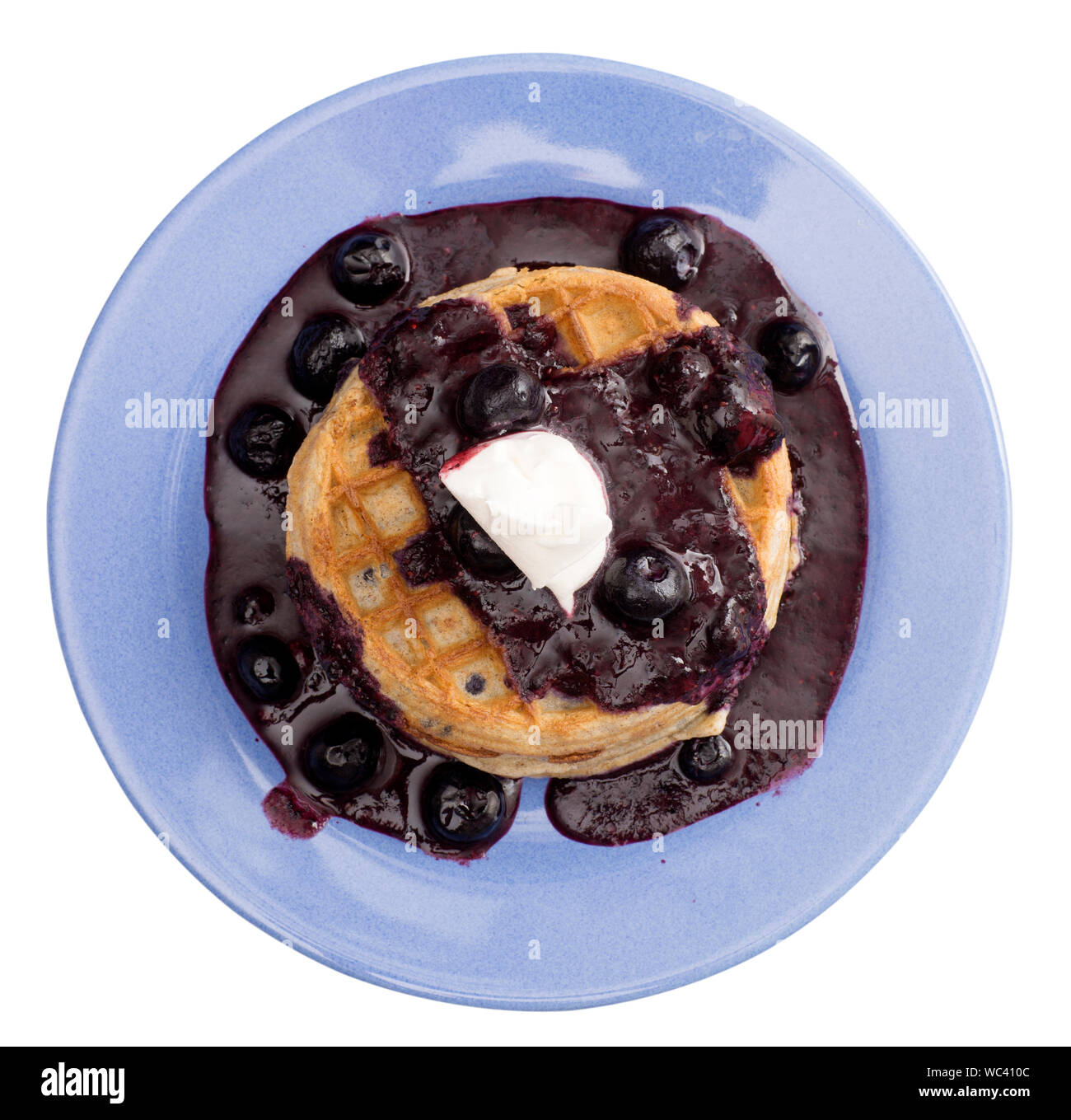 Stack of three blueberry waffles with whipped cream and syrup-on blue ...