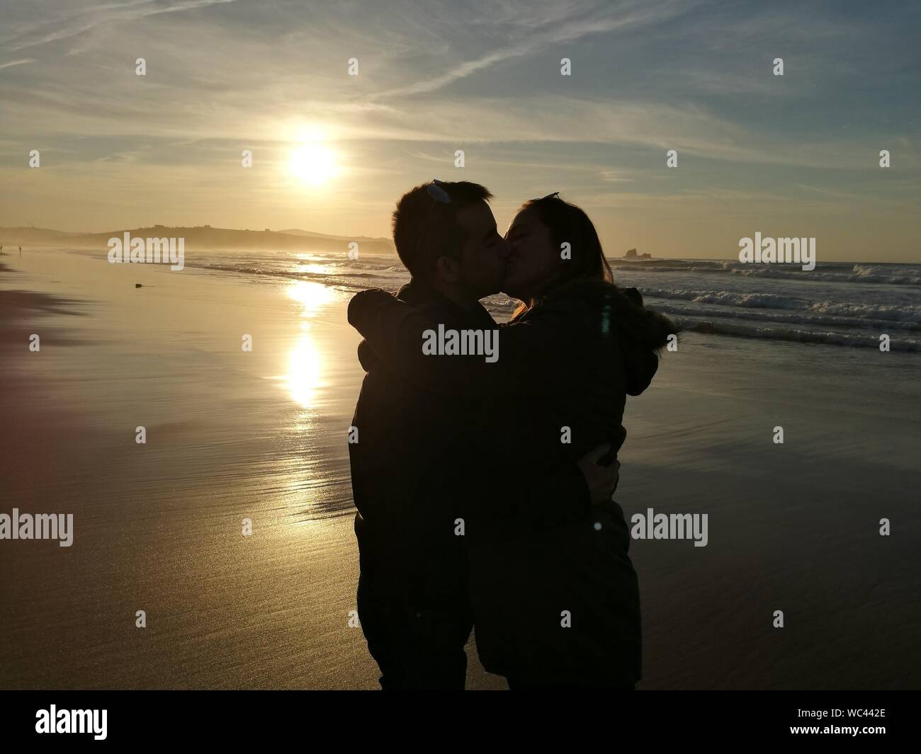 Affectionate young couple kissing beach hi-res stock photography and ...