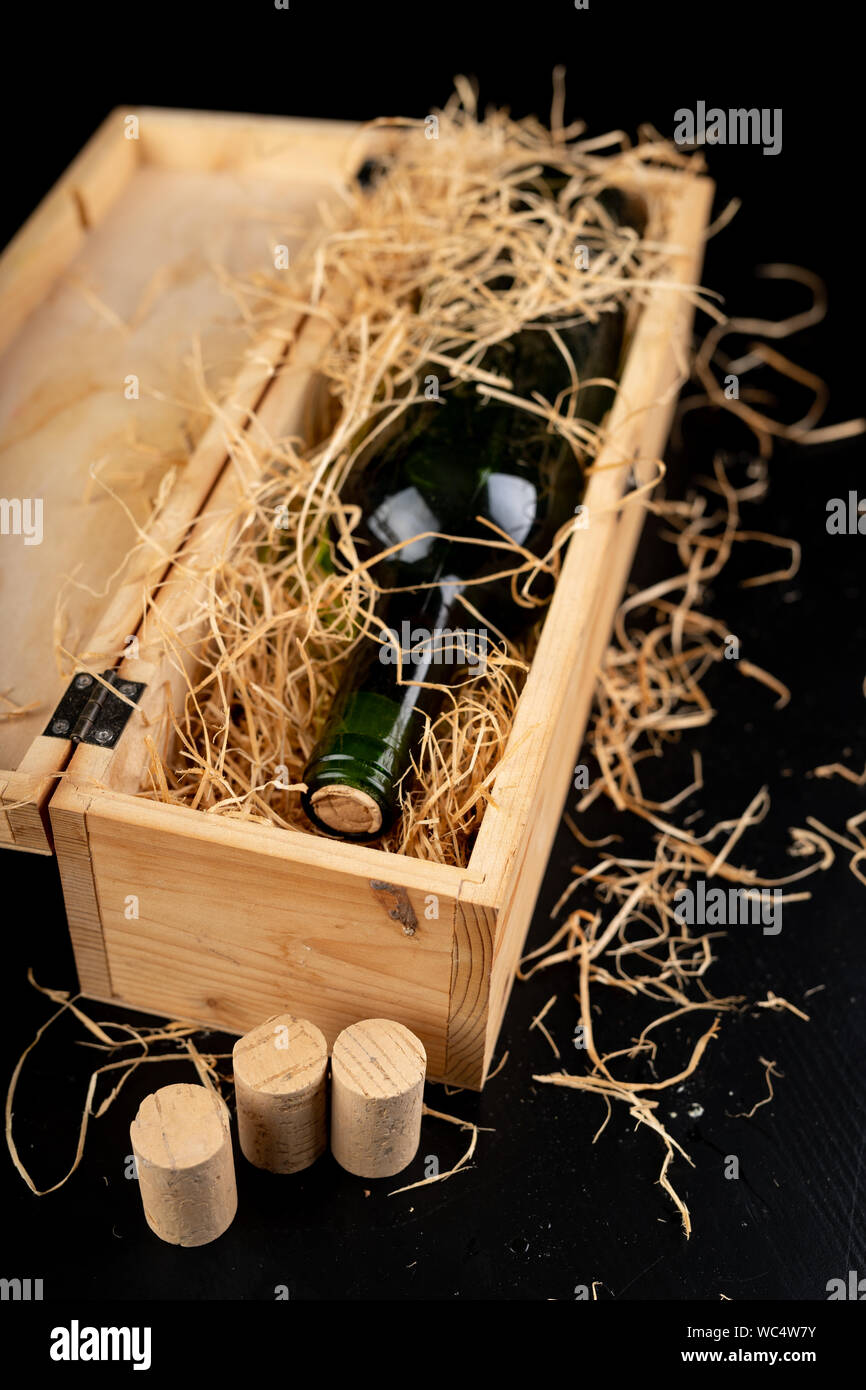 A bottle of wine in a wooden box. A tasty alcoholic drink in an elegant ...