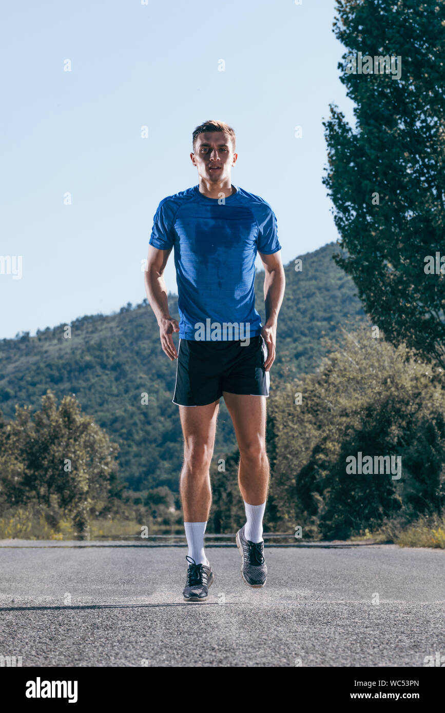 Handsome blonde athlete runner jumping at the middle of a highway Stock ...