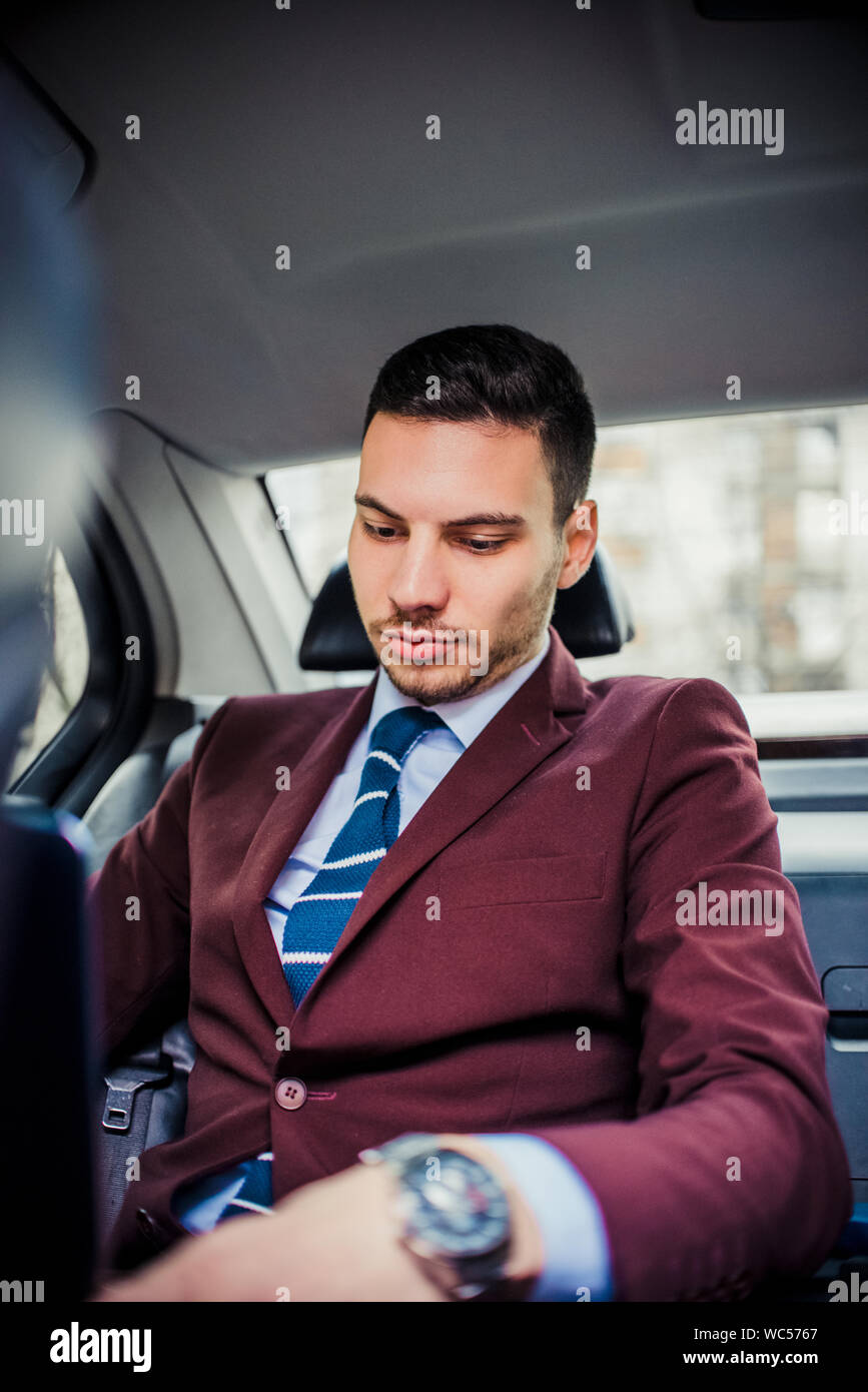 Elegant man in suit is going to a meeting while driving in a limo Stock ...