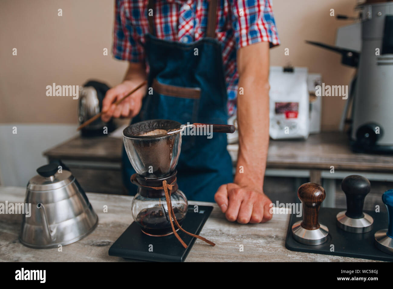 Portrait of a young waiter making cup of coffee at coffee shop Stock ...