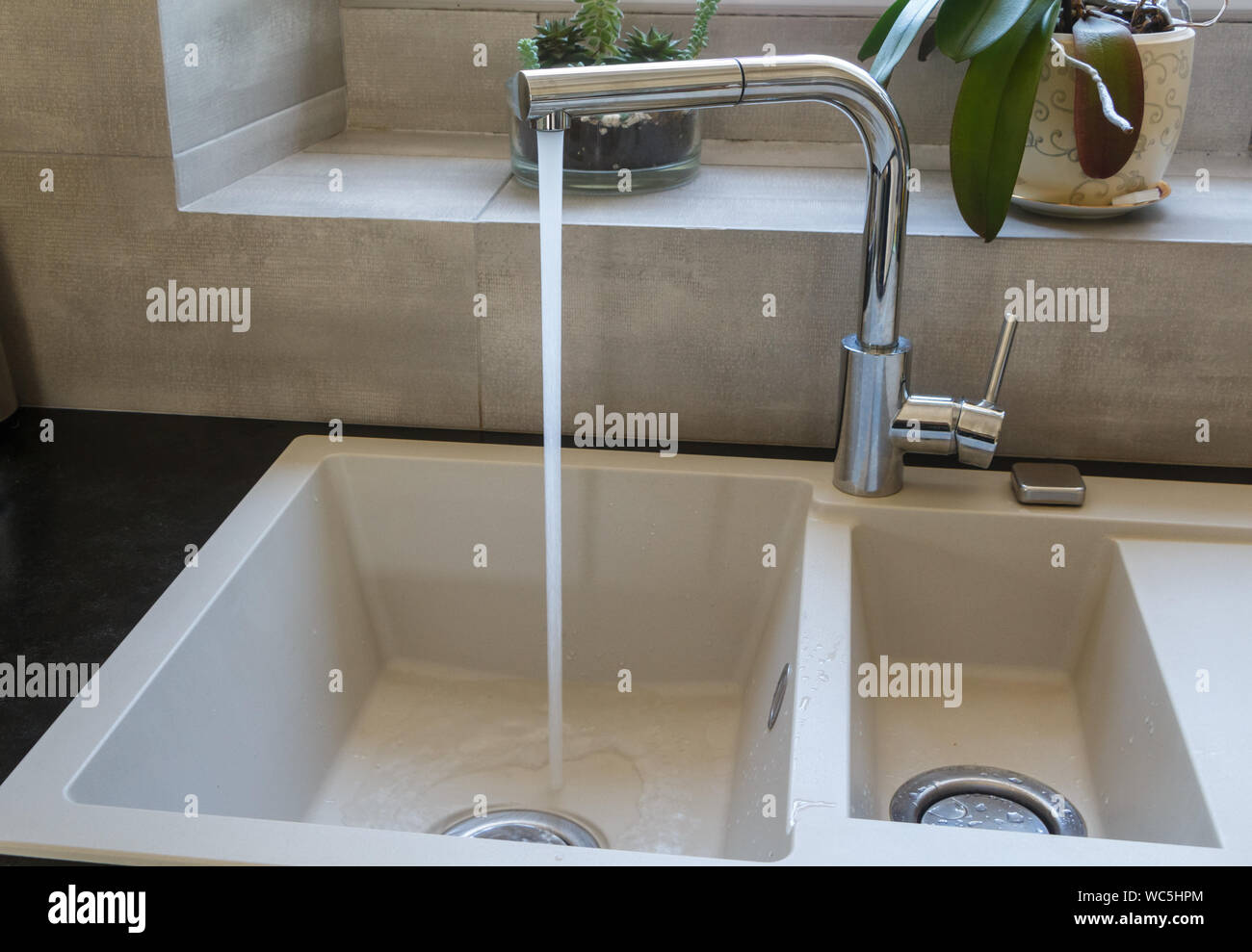 Sink of a kitchen with water flowing Stock Photo - Alamy