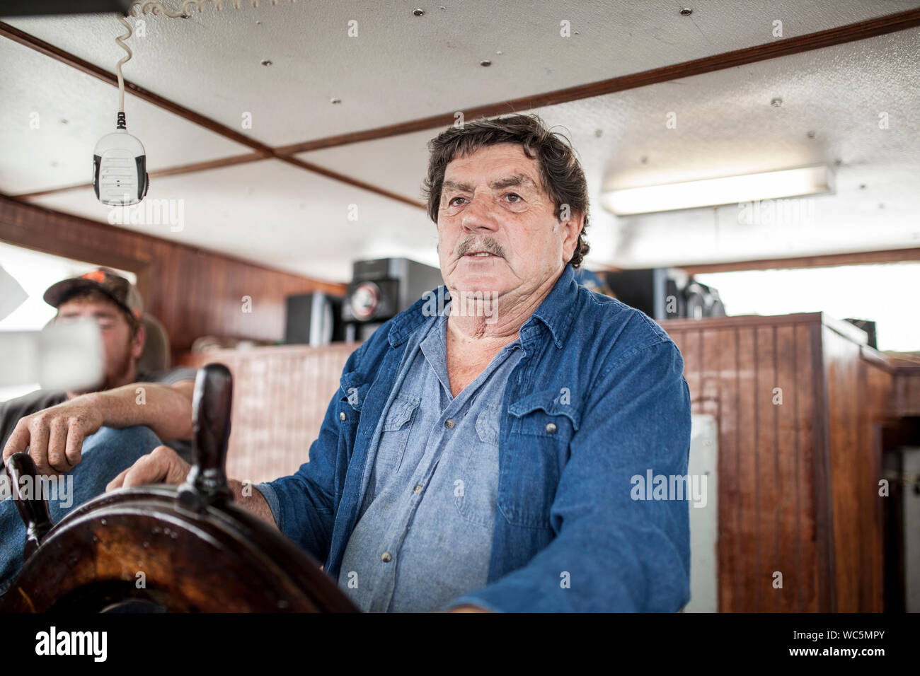 Ship captain at the helm of a fishing vessel Stock Photo - Alamy