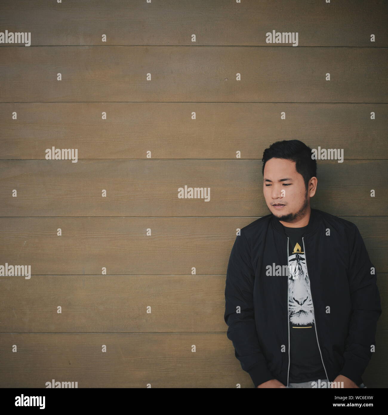 Young Man Standing Against Wall Stock Photo - Alamy