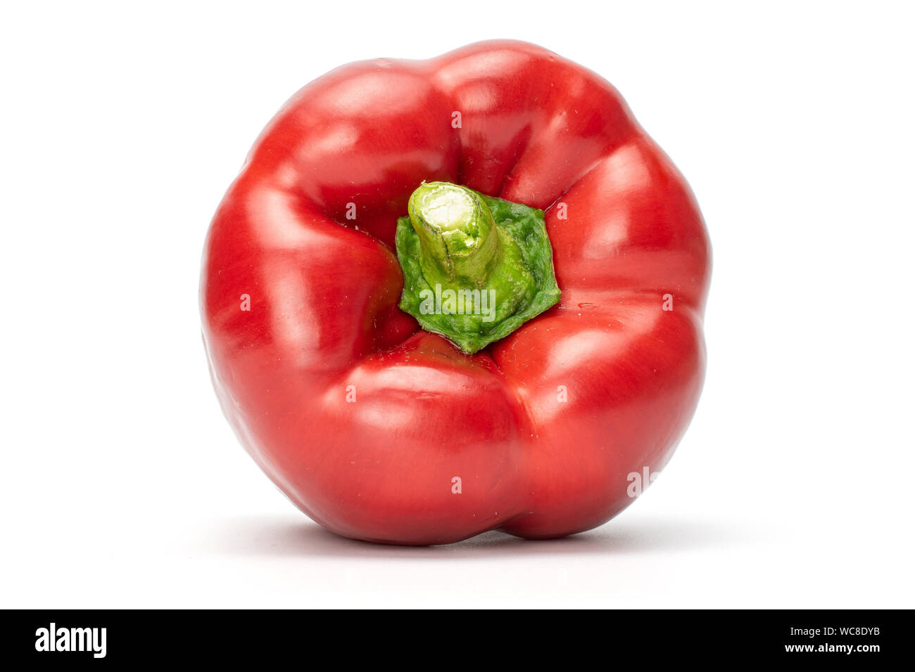 One whole red bell pepper front view with green stem isolated on white ...