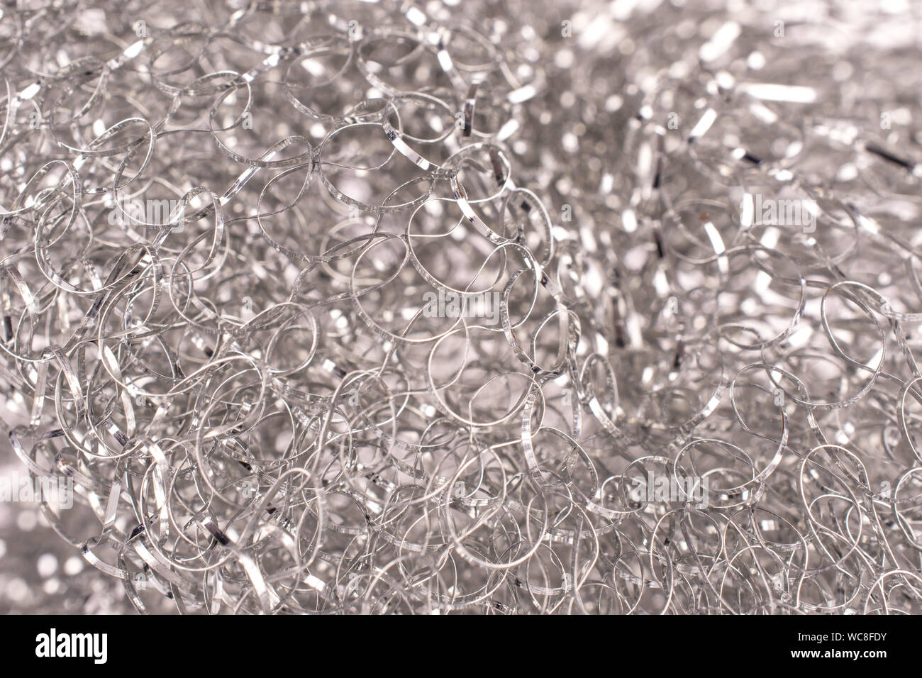 Silver cleaning kitchen sponge macro isolated Stock Photo - Alamy