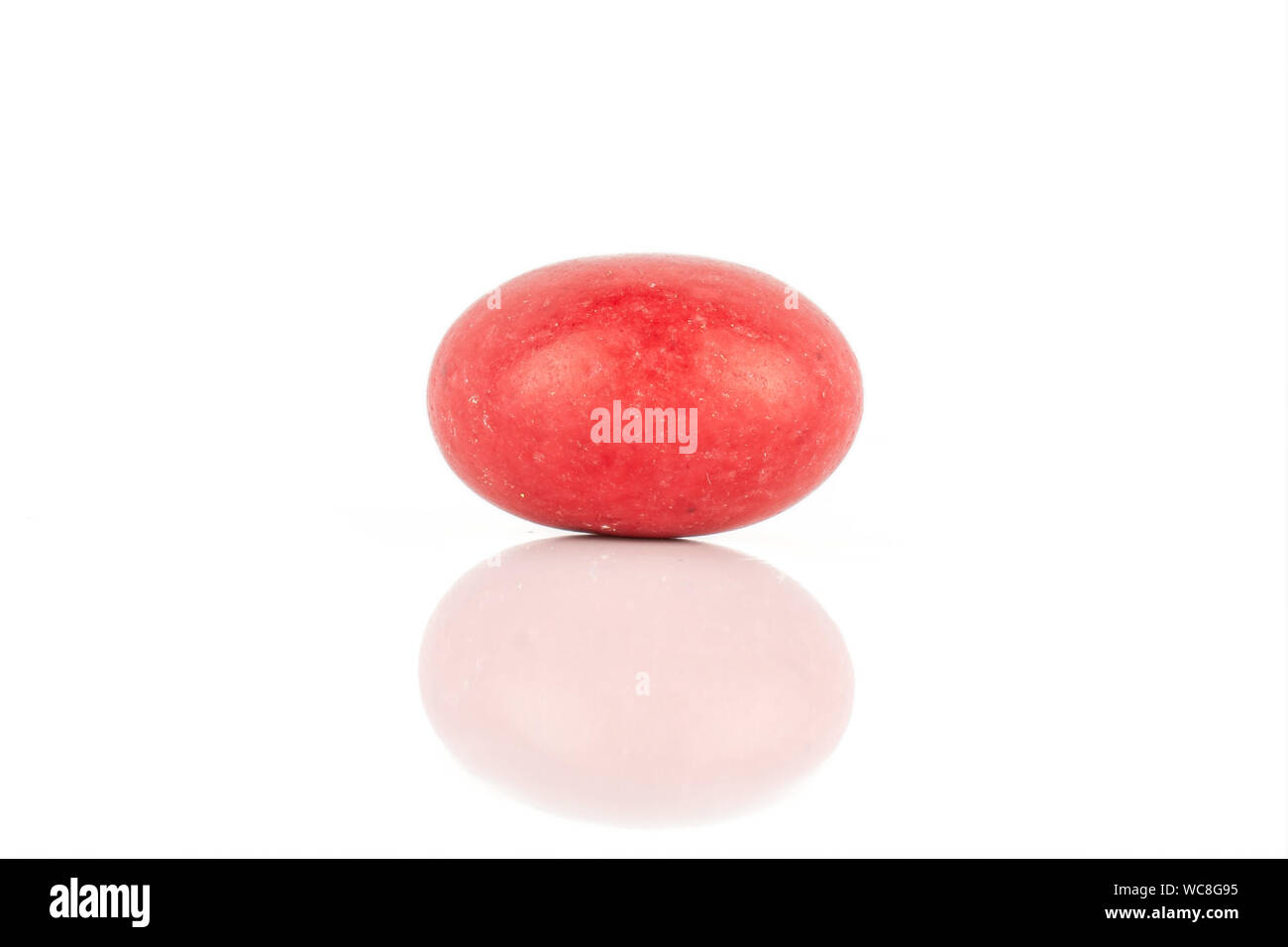 One whole red sugared nut dragee isolated on white background Stock ...