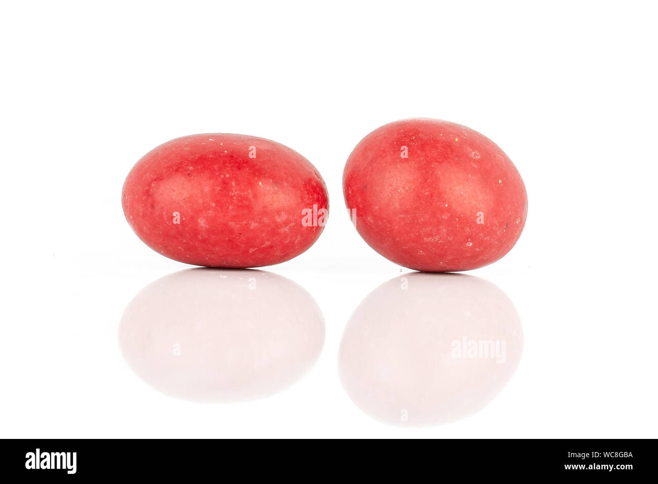 Group of two whole red sugared nut dragee isolated on white background ...