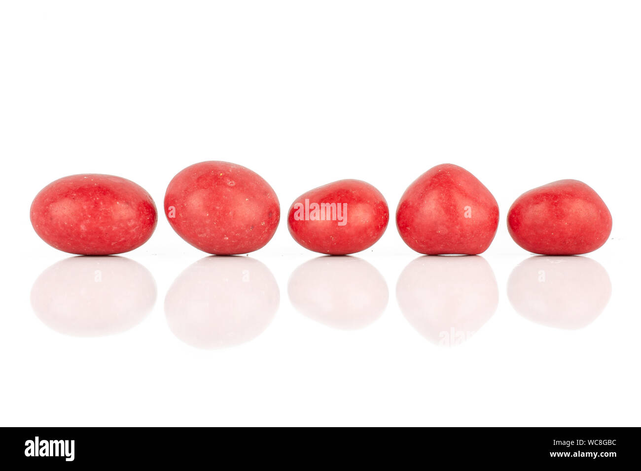 Group of five whole red sugared nut dragee isolated on white background ...