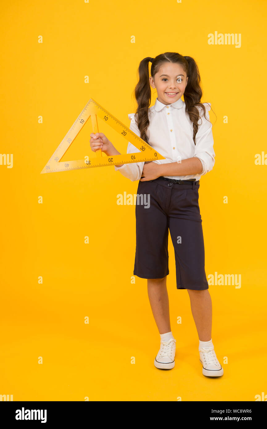 Pupil solving geometric problems. Cute small pupil holding triangle on ...