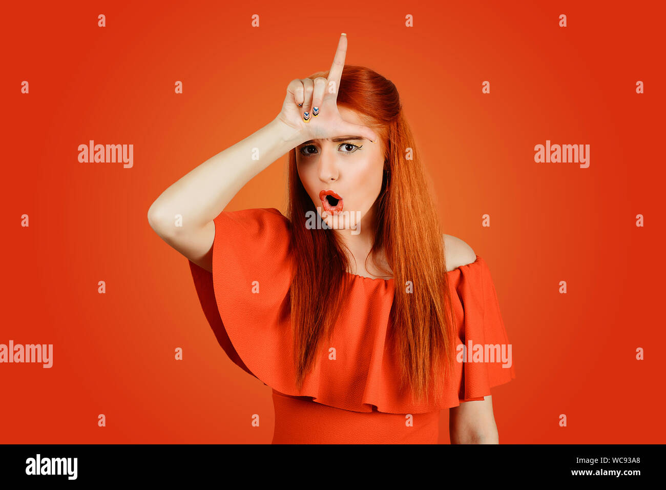 Closeup portrait young unhappy woman giving loser sign on forehead ...