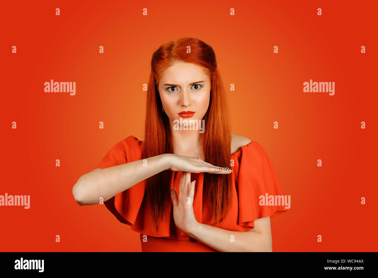 A serious young woman is showing sign of time-out looking at camera ...