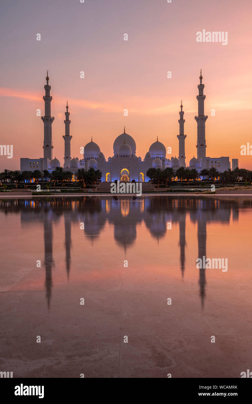 Sheikh Zayed Grand Mosque at sunset reflected in the Oasis of Dignity ...