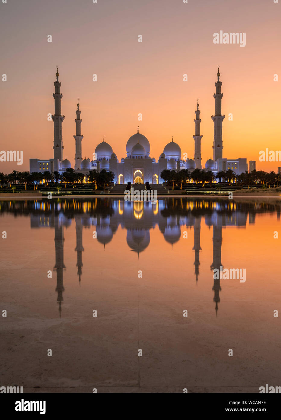 Sheikh Zayed Grand Mosque at sunset reflected in the Oasis of Dignity ...