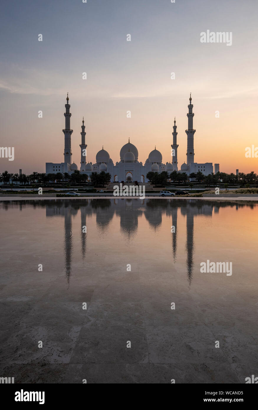 Sheikh Zayed Grand Mosque at sunset reflected in the Oasis of Dignity ...