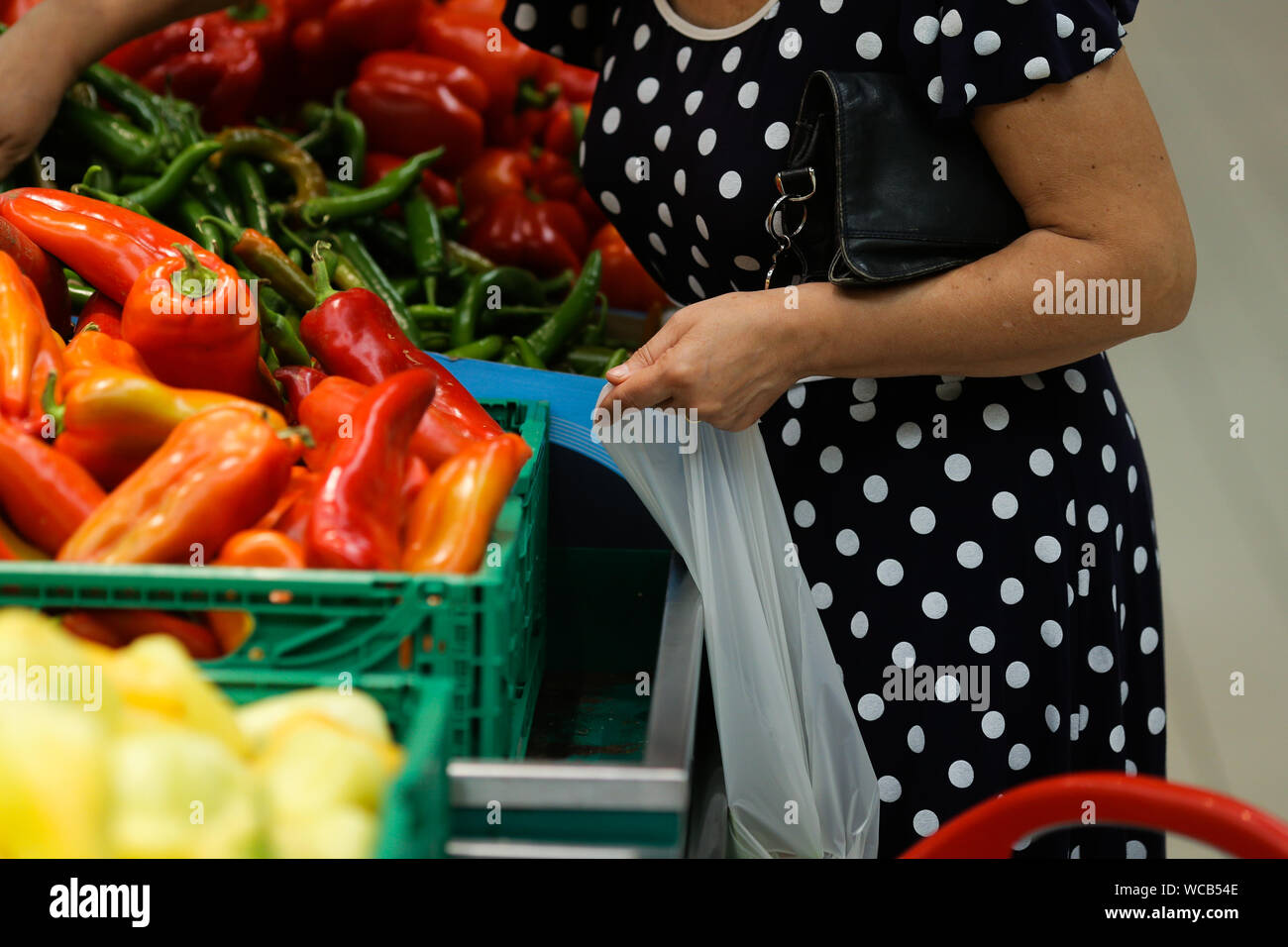 A woman uses biodegradable plastic food bags to buy fruits and ...