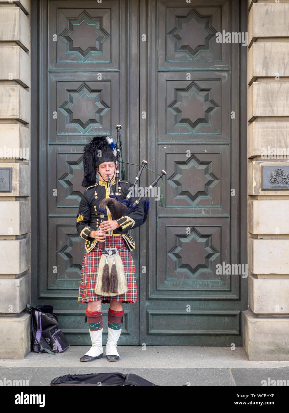 A Scotsman wearing traditional Scottish outfit playing the bagpipes ...