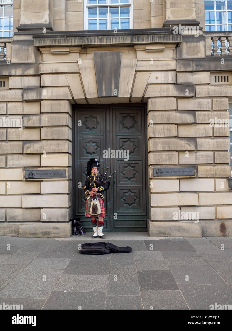 A Scotsman wearing traditional Scottish outfit playing the bagpipes ...