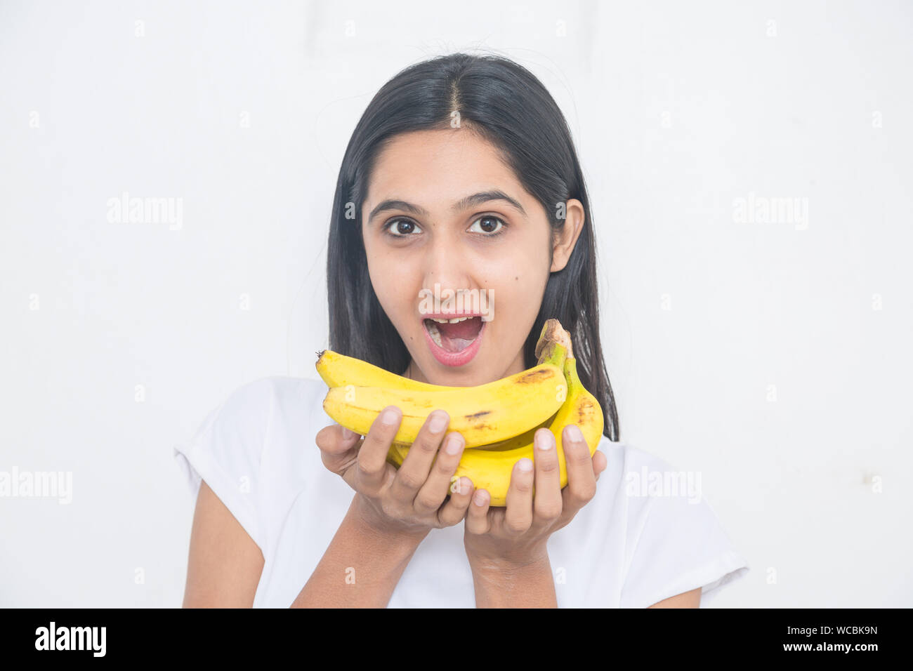 Young Asian Girl Holding Ripe Fresh Organic Yellow Banana Isolated On