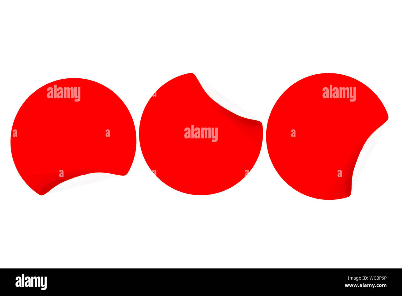 Set of three blank red stickers with curled side on a white background ...