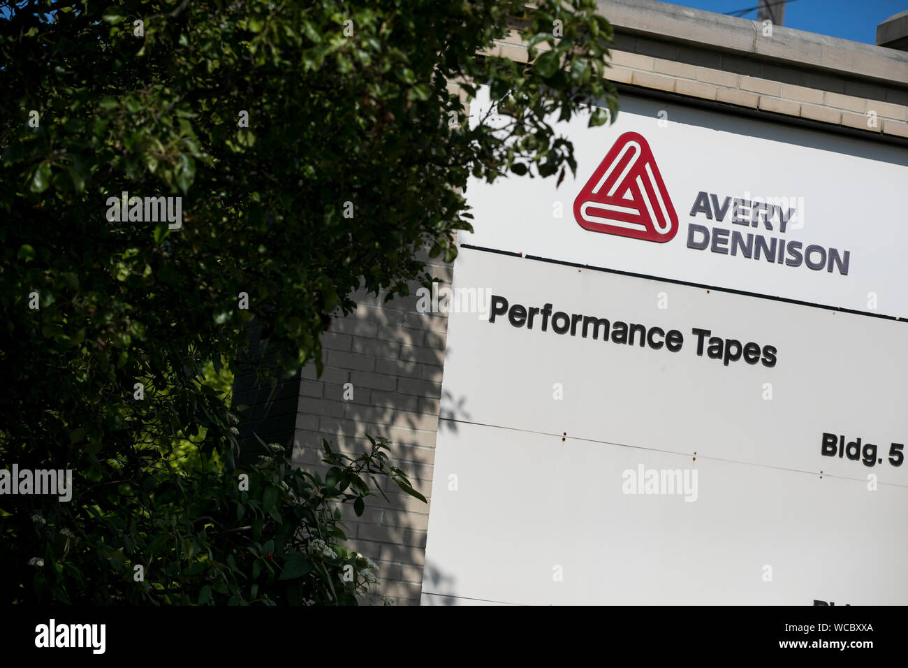 A logo sign outside of a facility occupied by Avery Dennison in ...