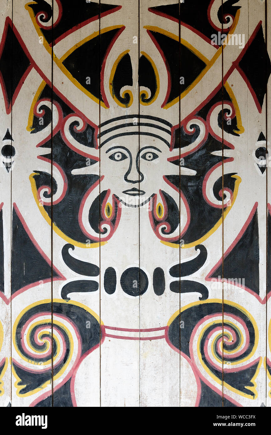 Traditional Dayak tribal culture. Totem in front of Dayak house - long ...