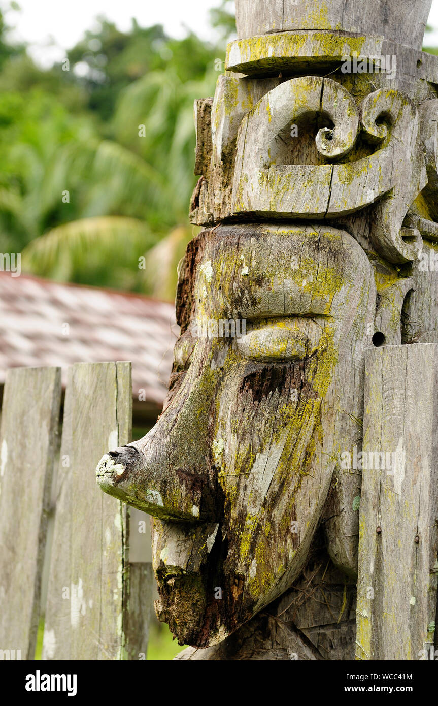 Traditional Dayak tribal culture. Totem in front of Dayak house - long ...