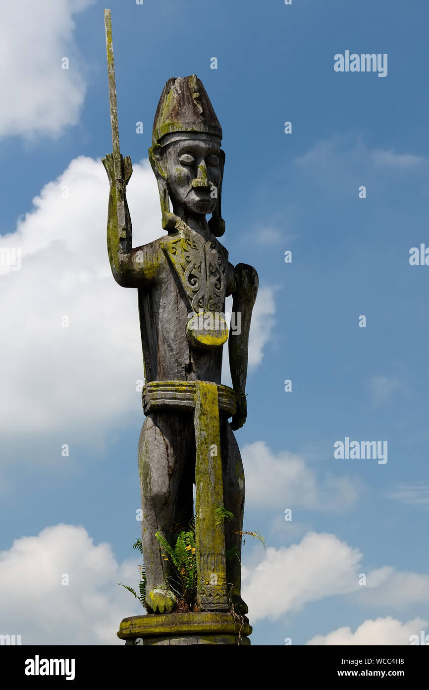 Traditional Dayak tribal culture. Totem in front of Dayak house - long ...