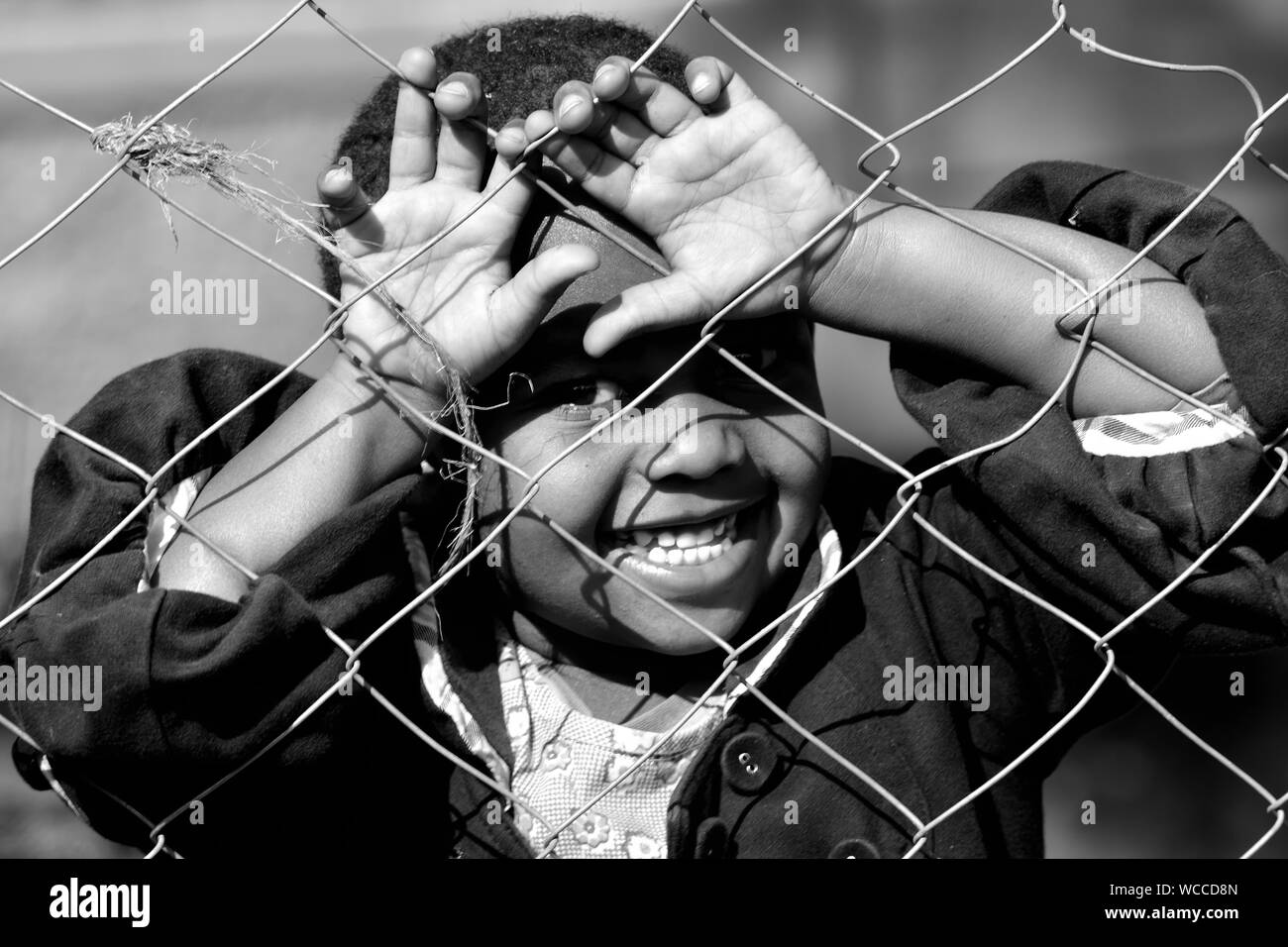 Girl looking through fence hi-res stock photography and images - Alamy