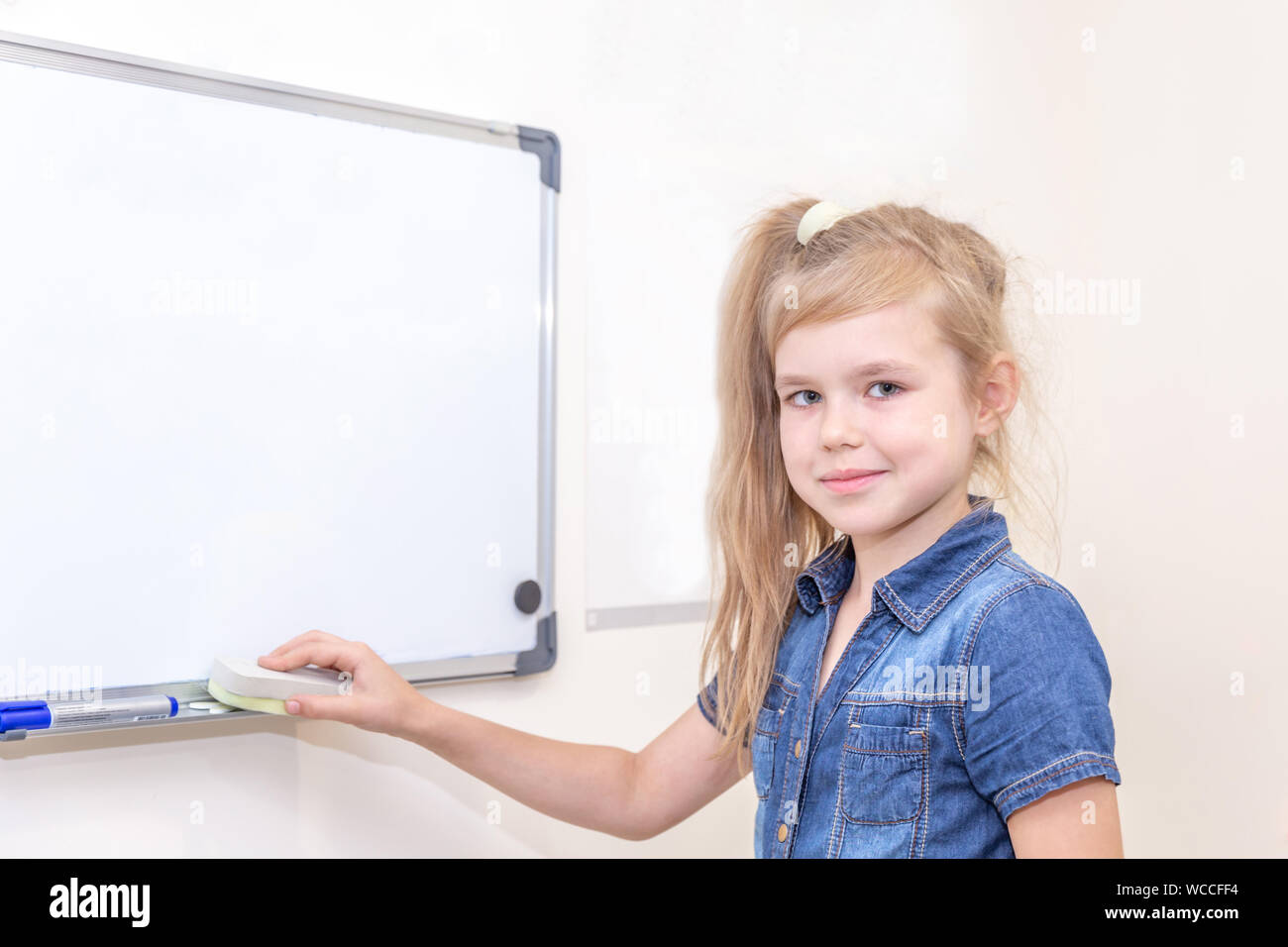 Little girl writing on board with a marker. Learning and school concept ...