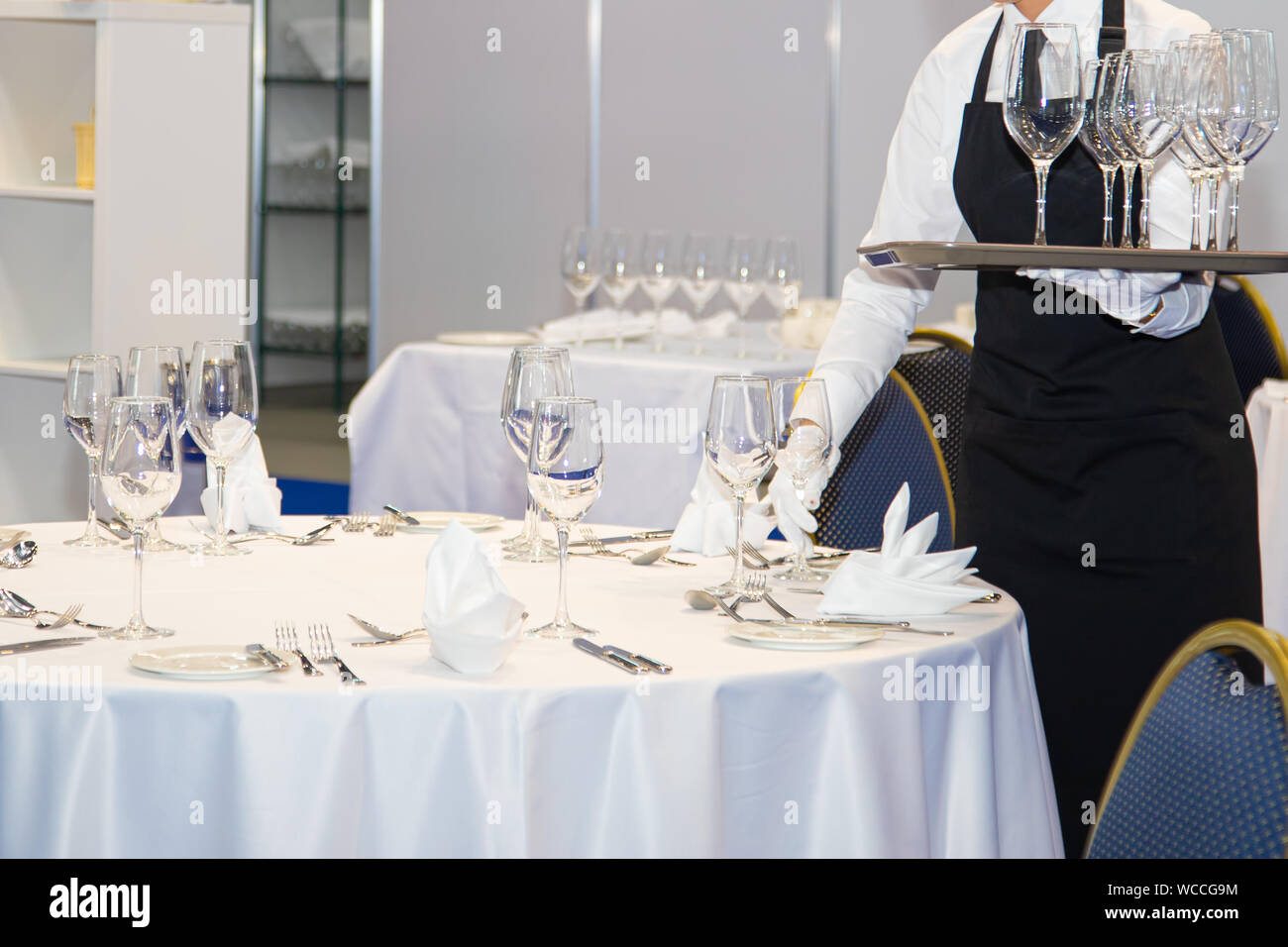 Waitress dressed in the uniform serving a set of wine glasses -selected ...