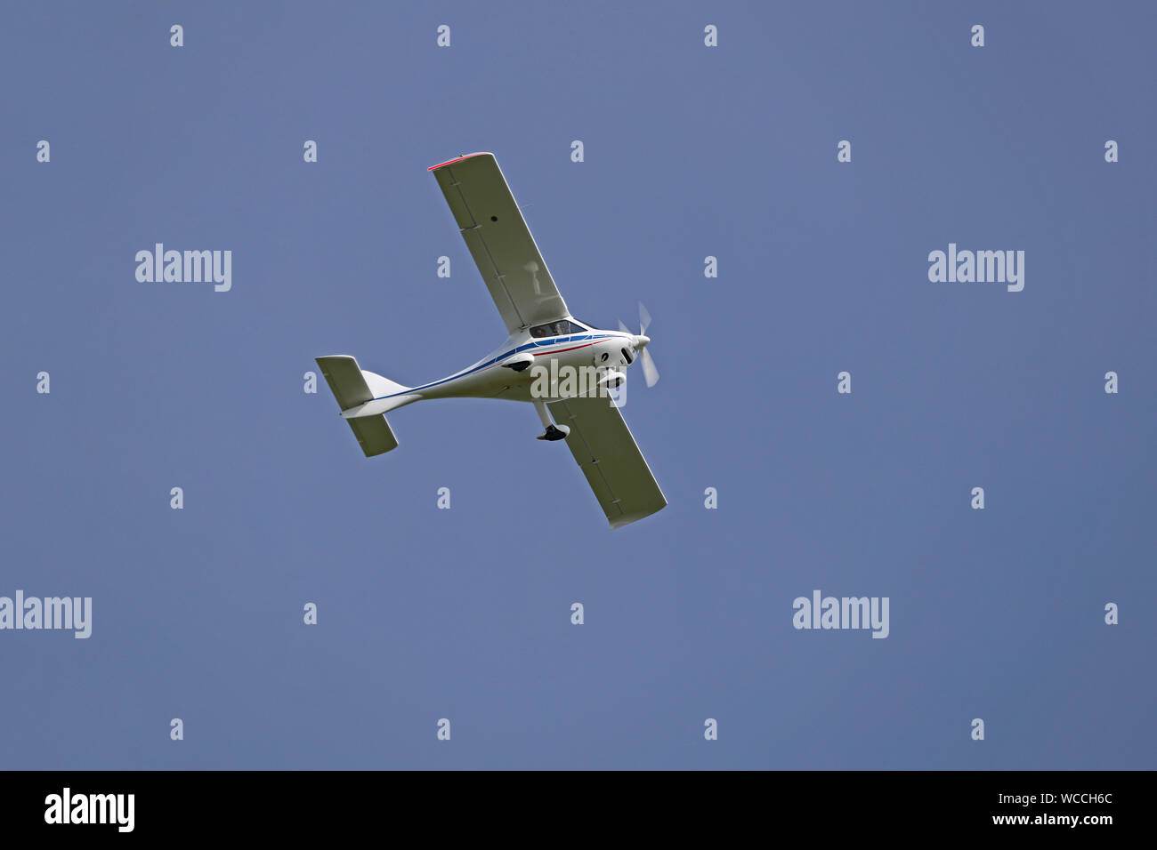 light aircraft flying low over a house in the country near ...