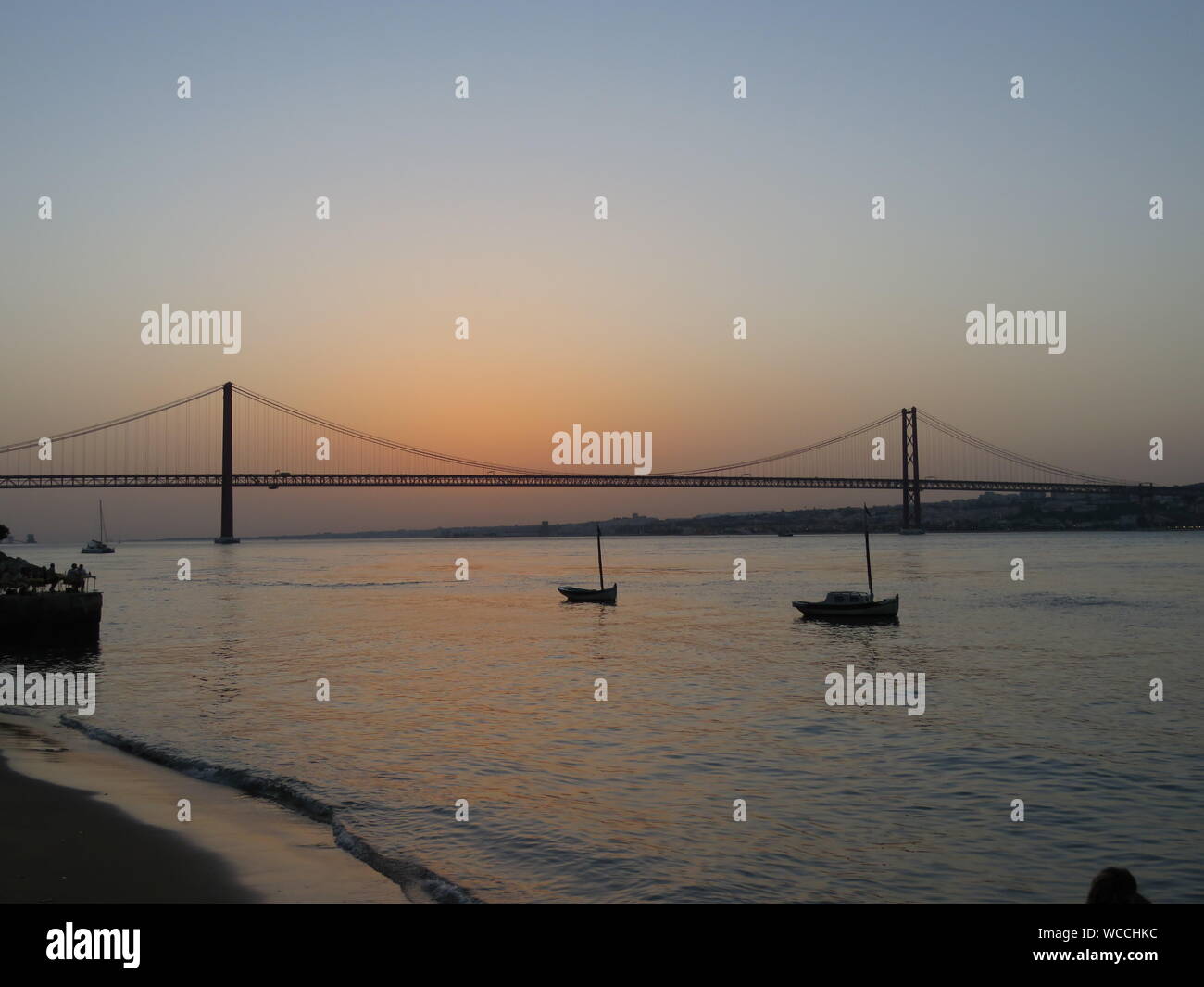 Boats On River By Bridge At Dusk Stock Photo - Alamy