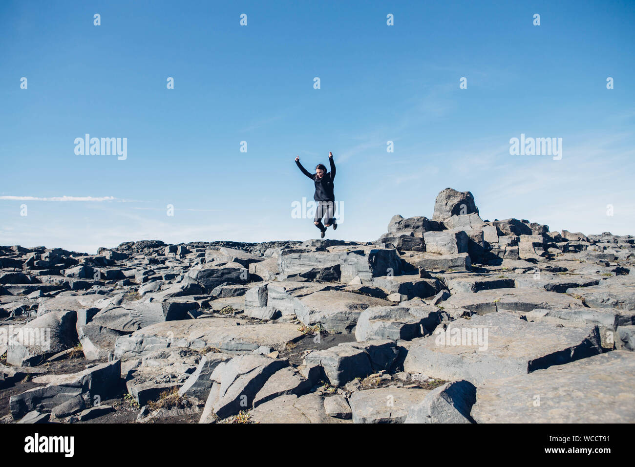 Woman jumping rock formation hi-res stock photography and images - Alamy